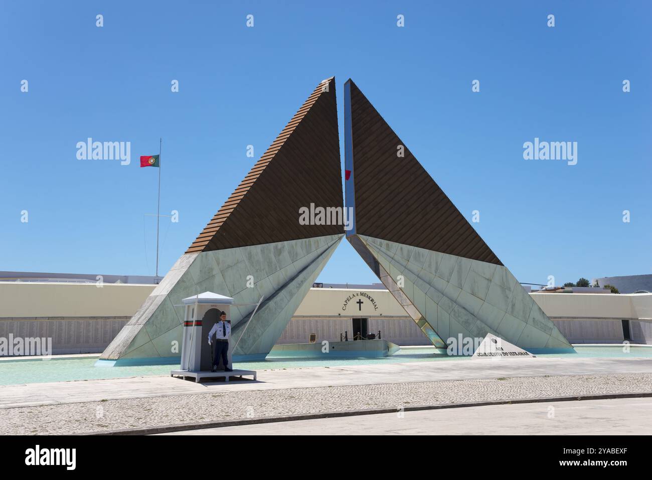 Modern, symmetrical structure with a water surface and flag background ...