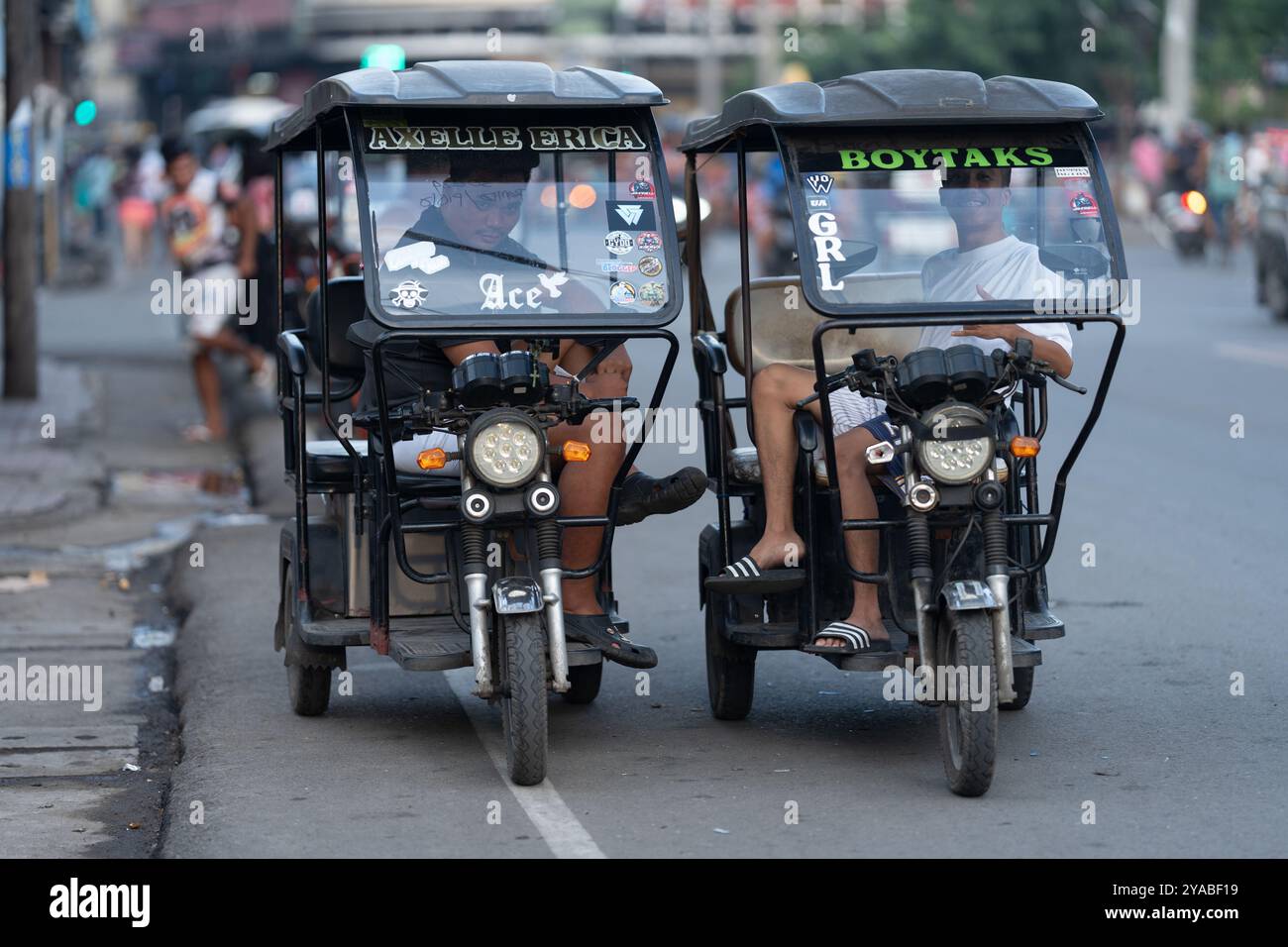 Two drivers are waiting for passengers in their electric, eco-friendly ...