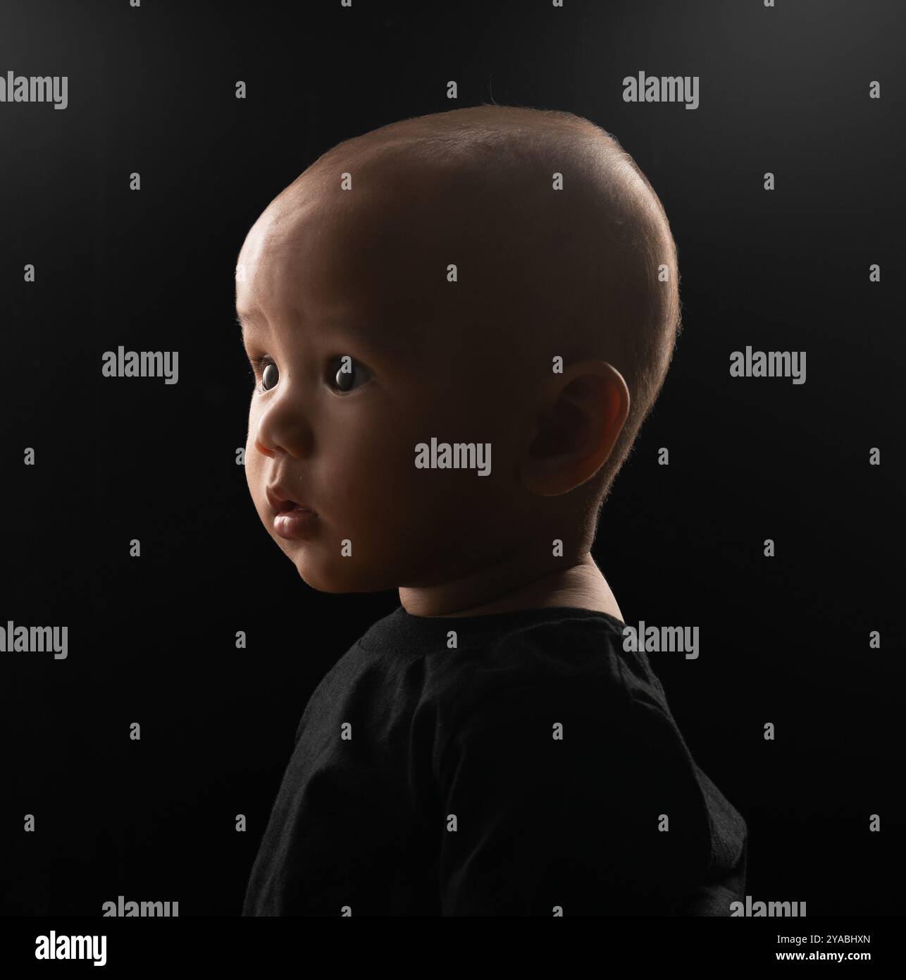 Adorable Profile of a Baby with a Shiny Bald Head in Dramatic Lighting ...