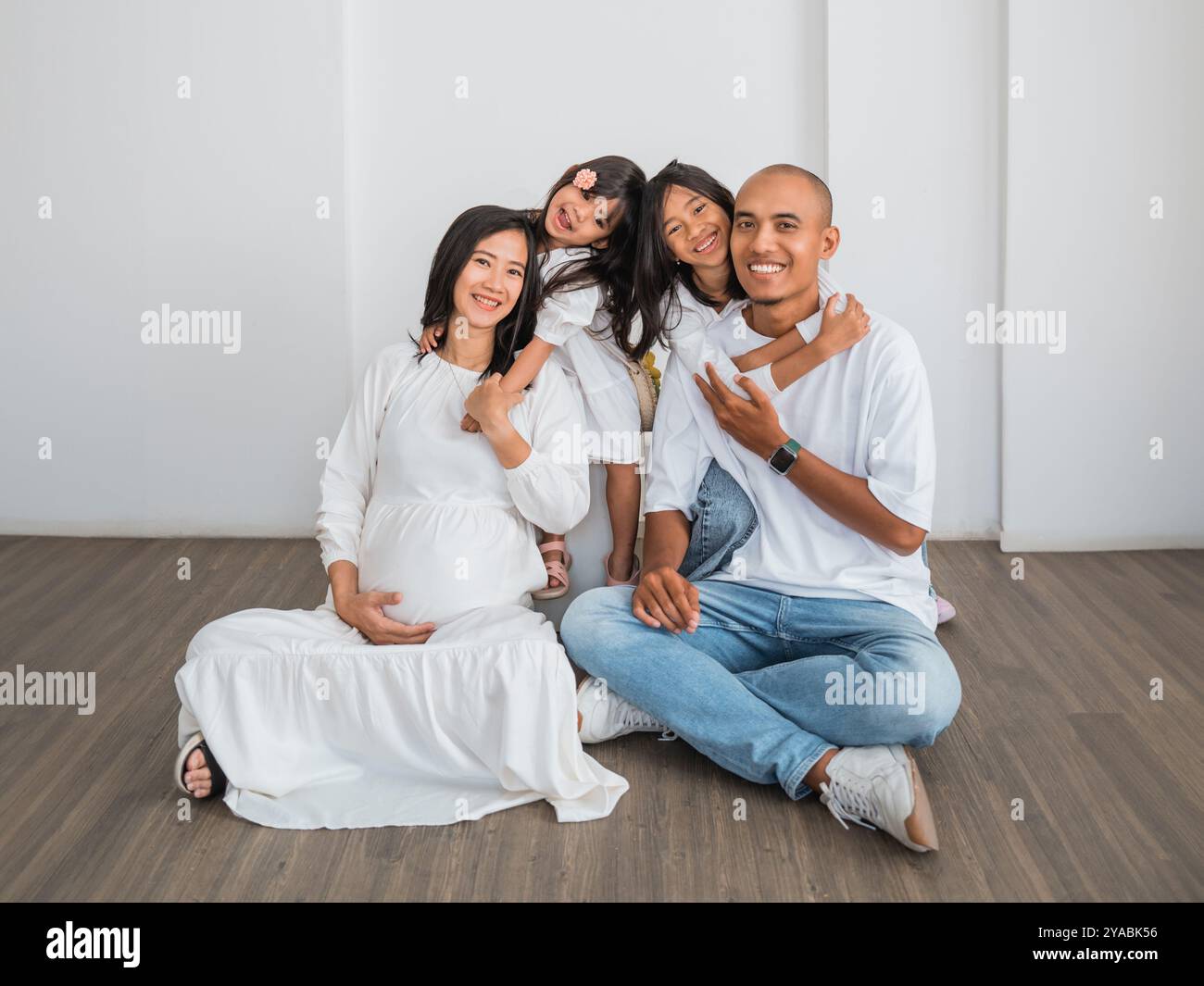 A happy family poses together on the floor for a picture Stock Photo ...
