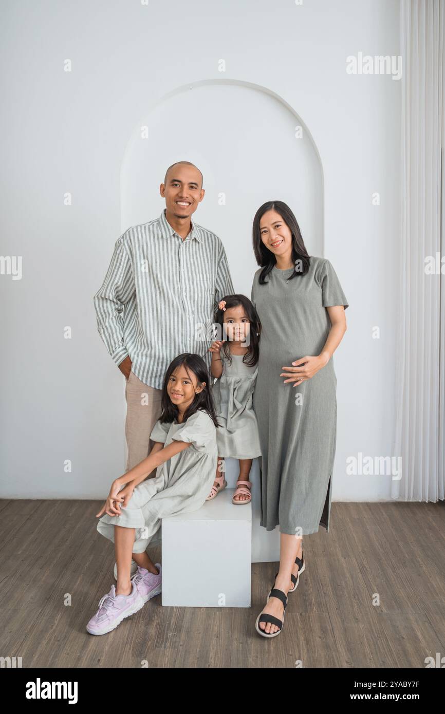 A family is joyfully posing for a memorable picture together in a room ...