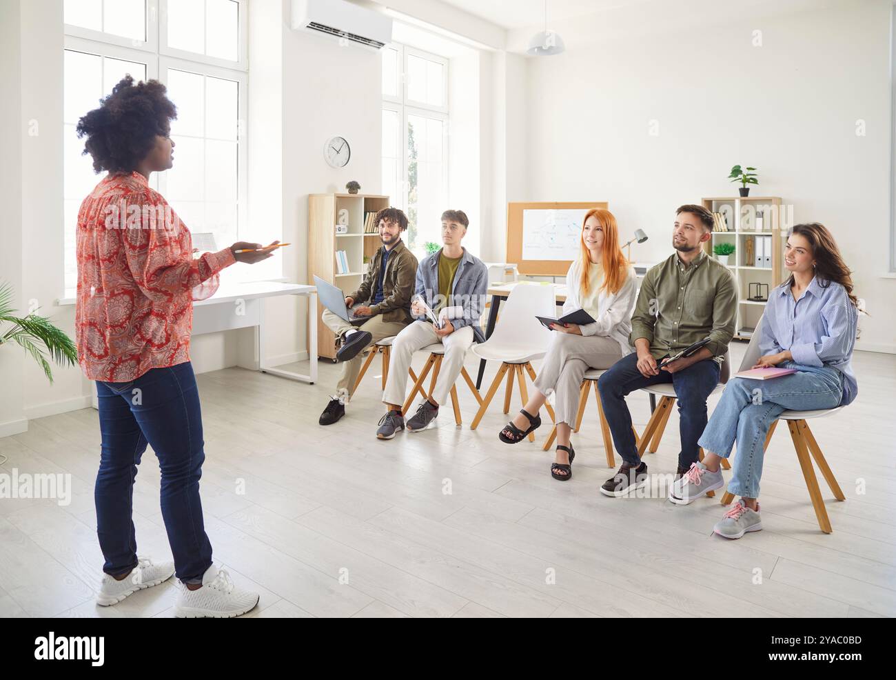 African American woman making presentation for group of students or ...