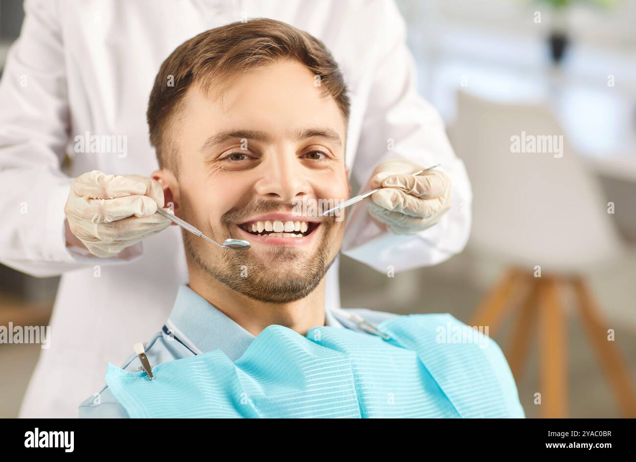 Male patient looking cheerful at camera in modern dentistry clinic ...