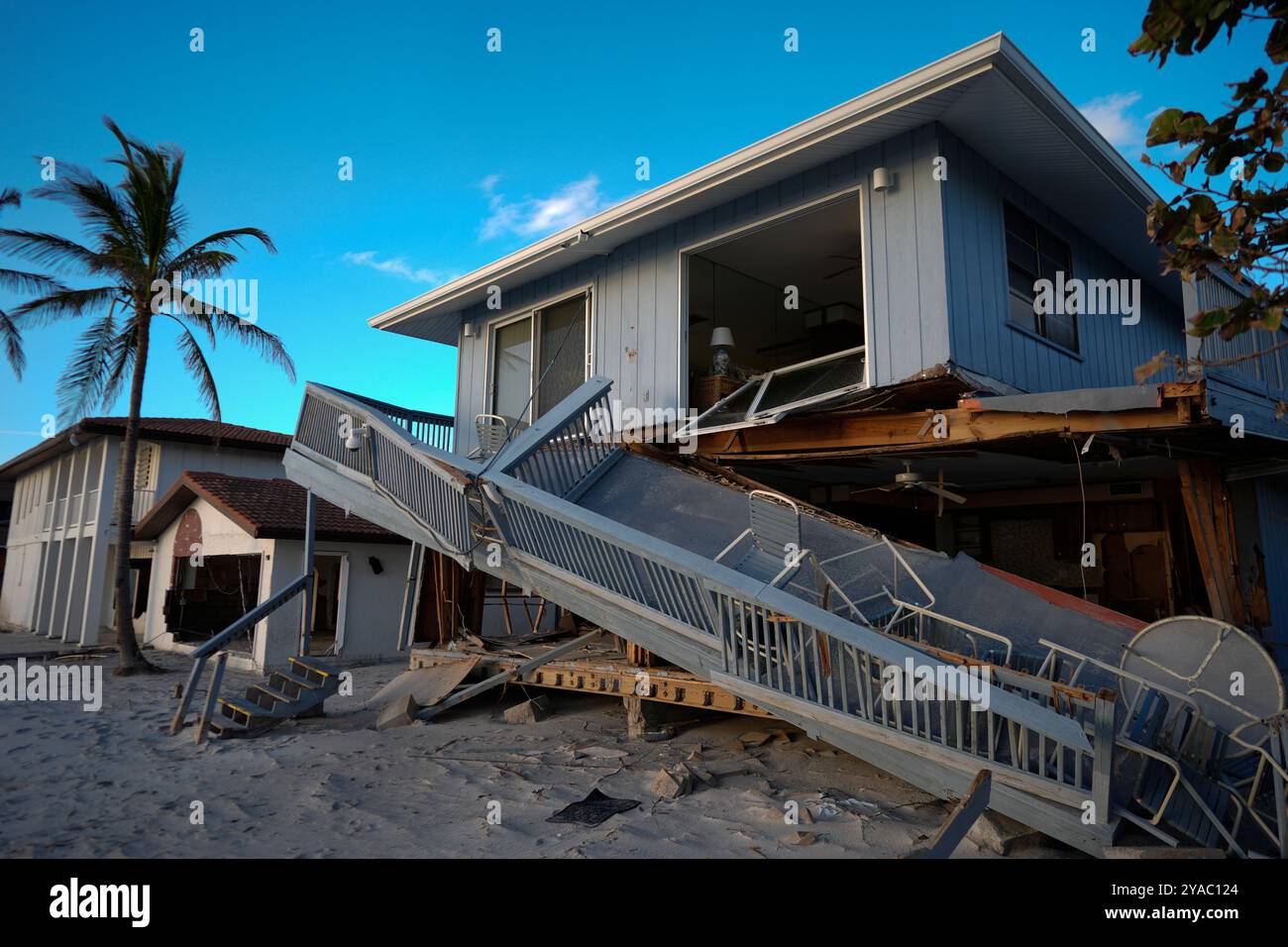 A balcony hangs from the front of a house destroyed in Hurricane Milton ...