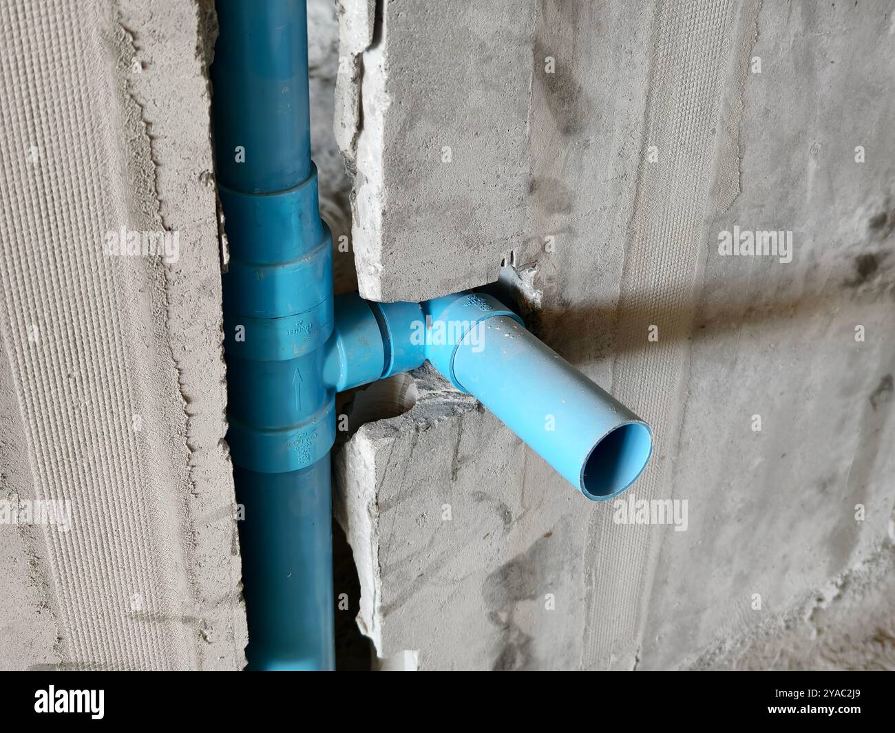 A bright blue pipes attached to a solid concrete wall Stock Photo - Alamy