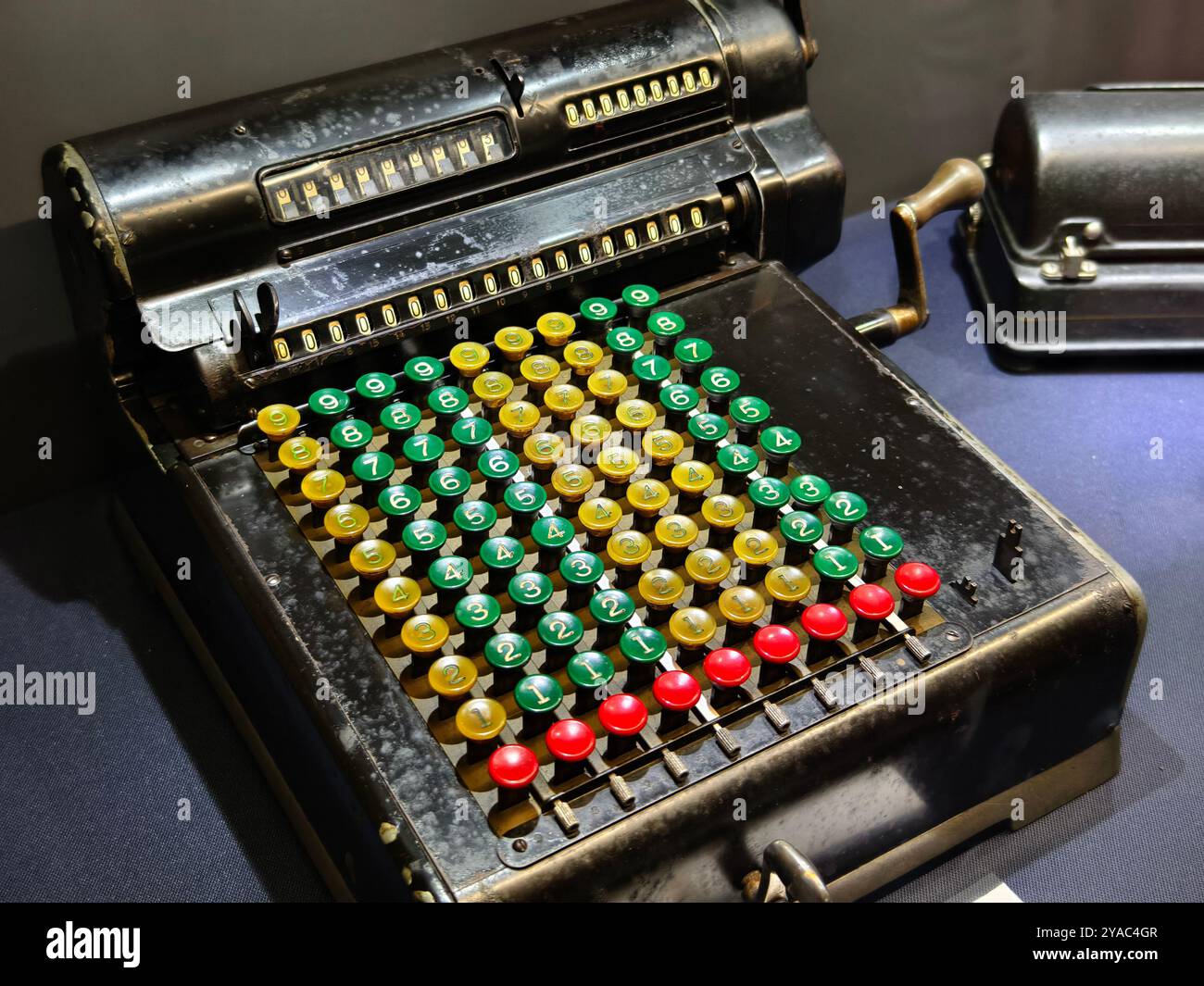 An old fashioned adding machine features a drawer located underneath it ...
