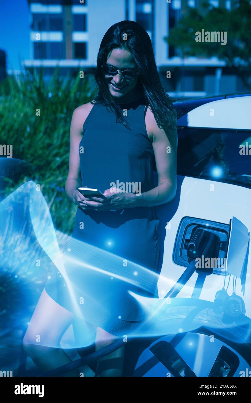 Blue wave against woman using mobile phone while charging electric car ...