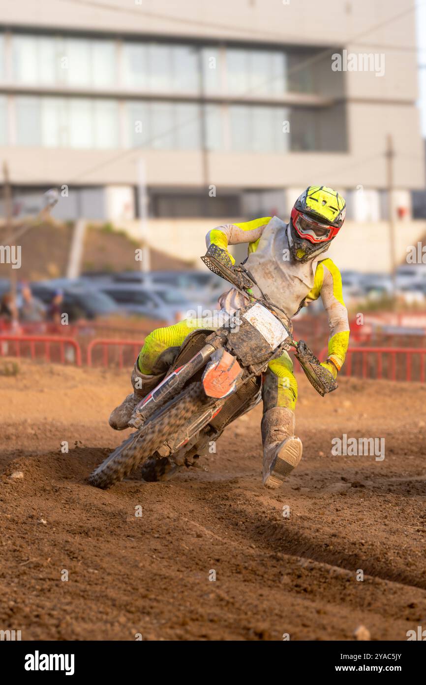 Motocross rider in action turning and folding his motorcycle with his ...