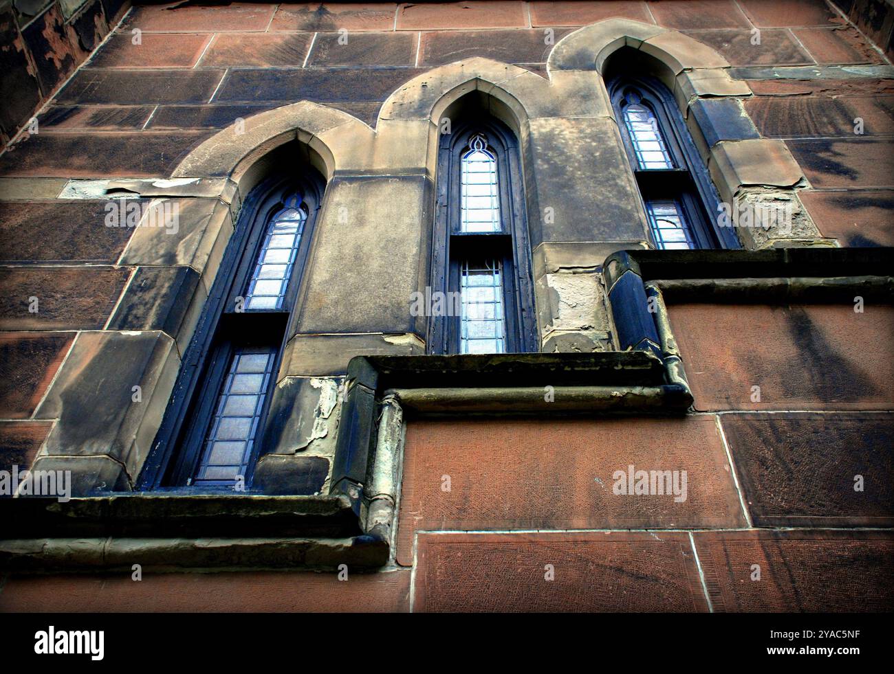 Photography of three staggered arched windows on the side of an old ...