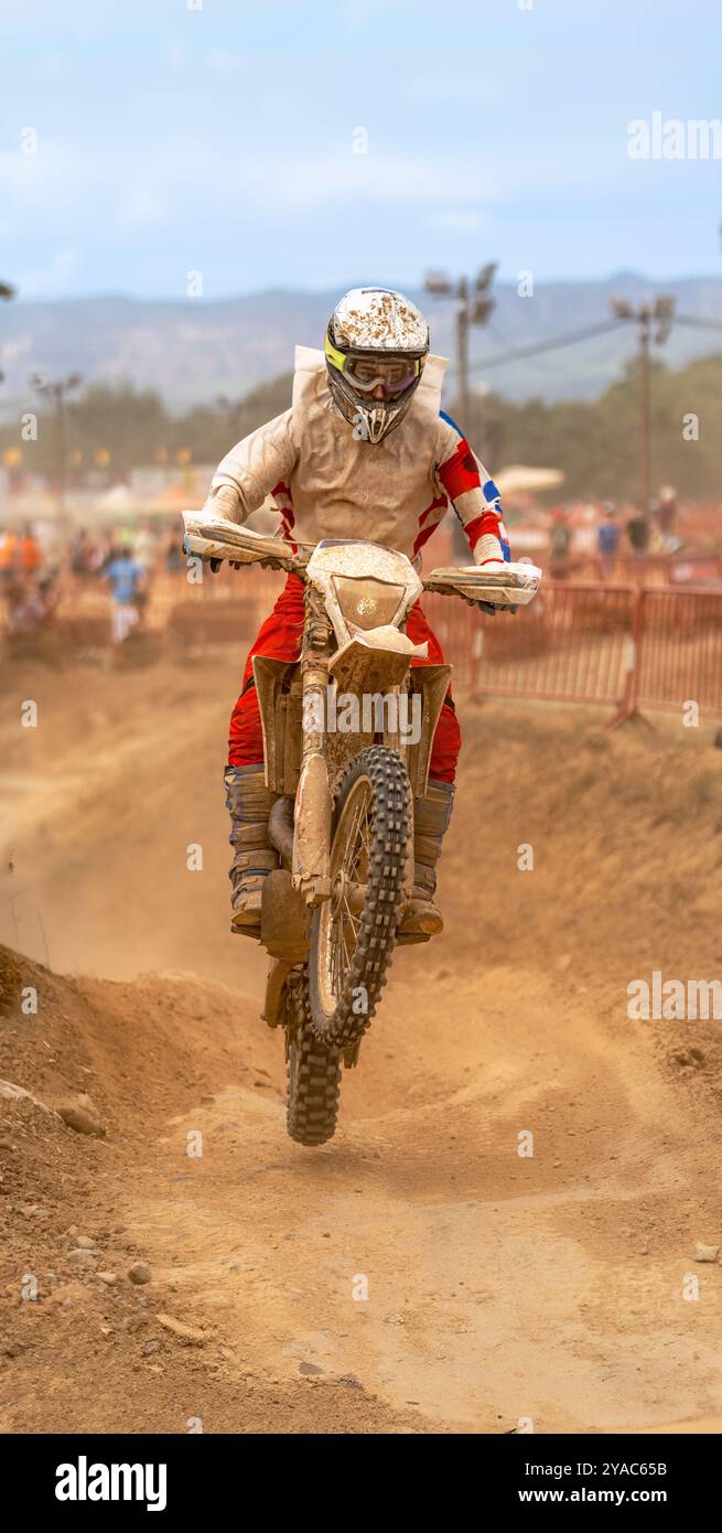 Motocross rider covered in mud and dust jumping his bike over the ...