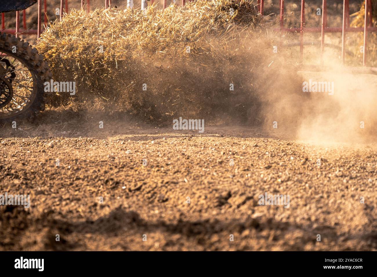 Dirt, gravel and dust kicked up by a motorcycle's knobby rear tire ...