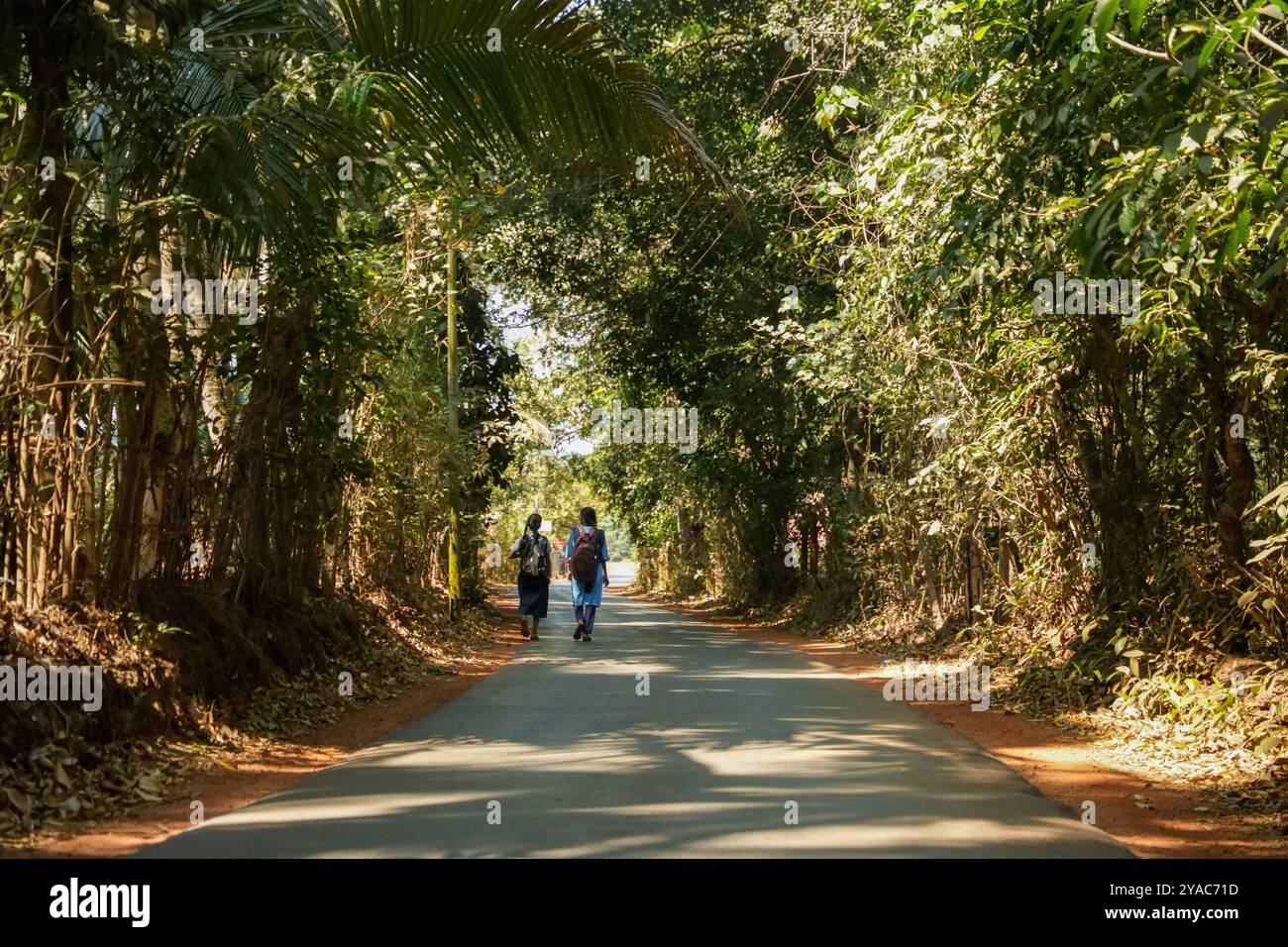 GOA, India - February 24, 2024: Two schoolgirls walking along the road ...