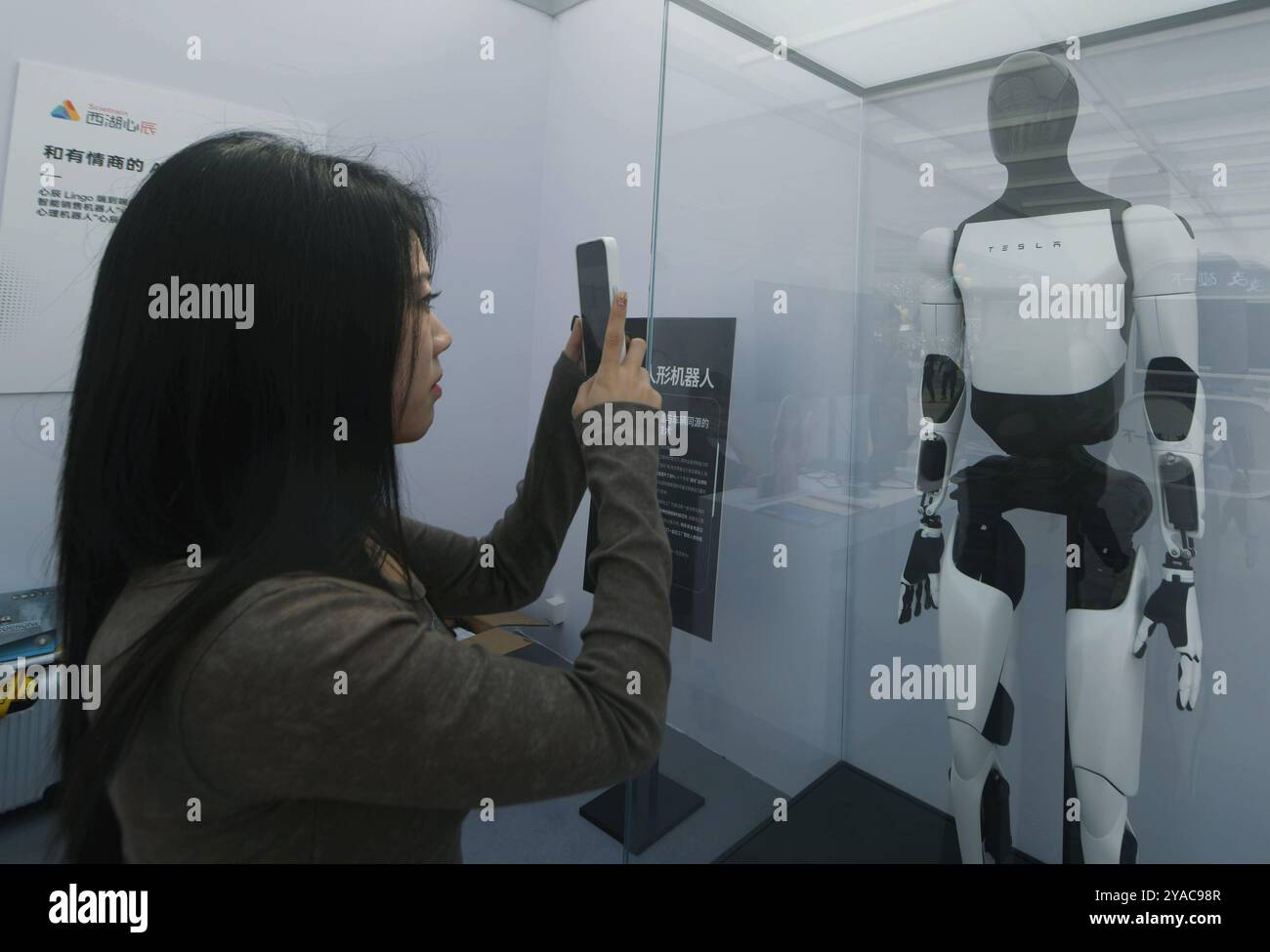 HANGZHOU, CHINA - OCTOBER 13, 2024 - People look at Tesla's humanoid ...