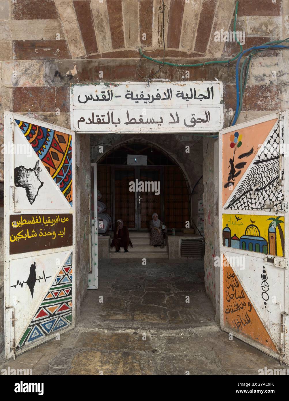 Members of the African community sit at the entrance to a residential ...