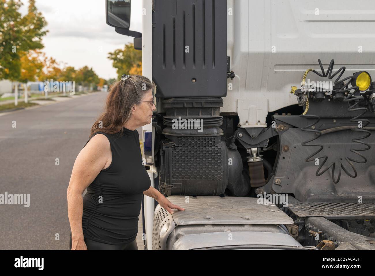 Driver checks her vehicle before driving off Stock Photo - Alamy