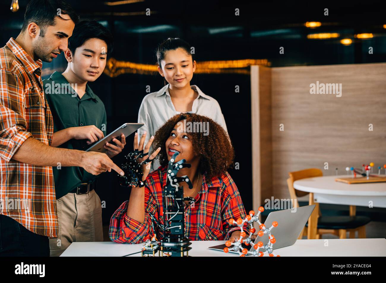 A classroom scene with students and teacher exploring a robotic arm for ...