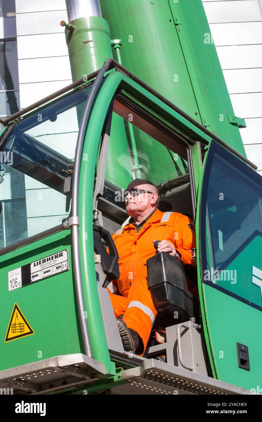 Crane operator at work in the cab of a crane Stock Photo - Alamy