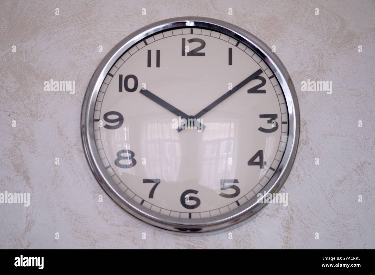 A large round clock with a black dial on the wall. Big white wall clock ...