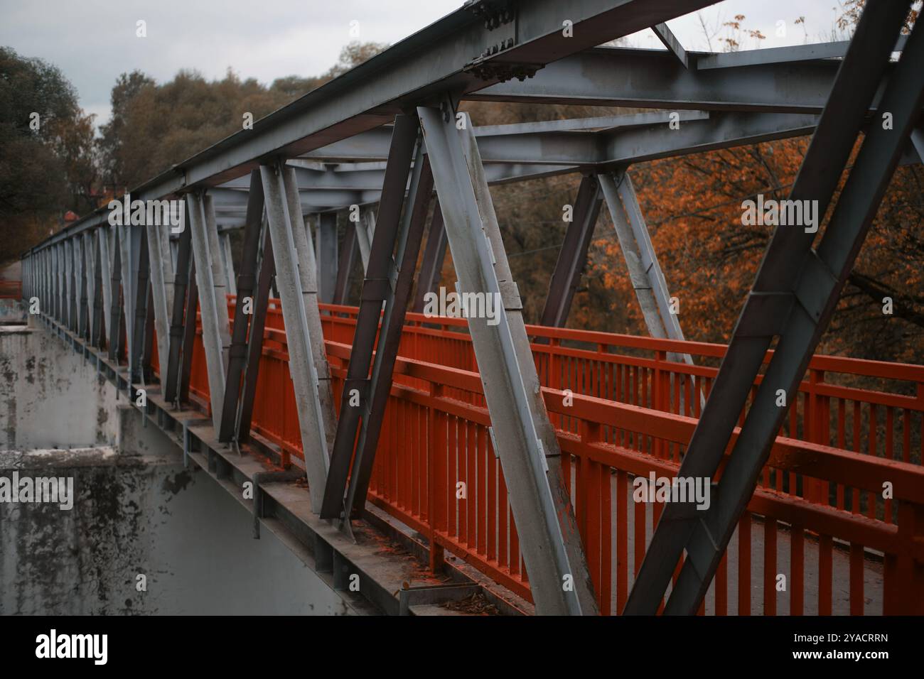 Pedestrian bridge over the river made of iron beams and with a red ...