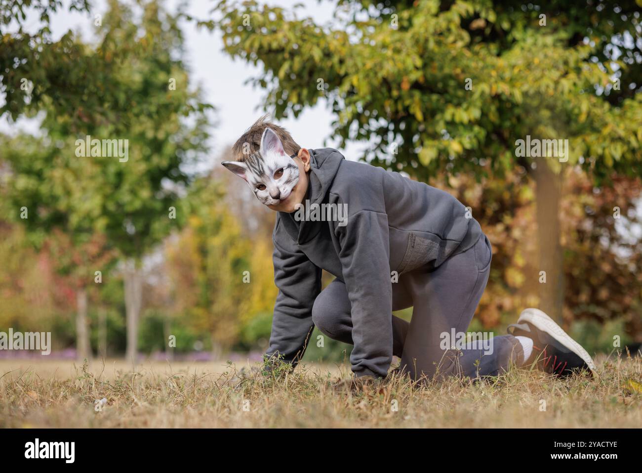 Teenage guy with cat mask and gloves doing Quadrobics. A Teenage guy in ...