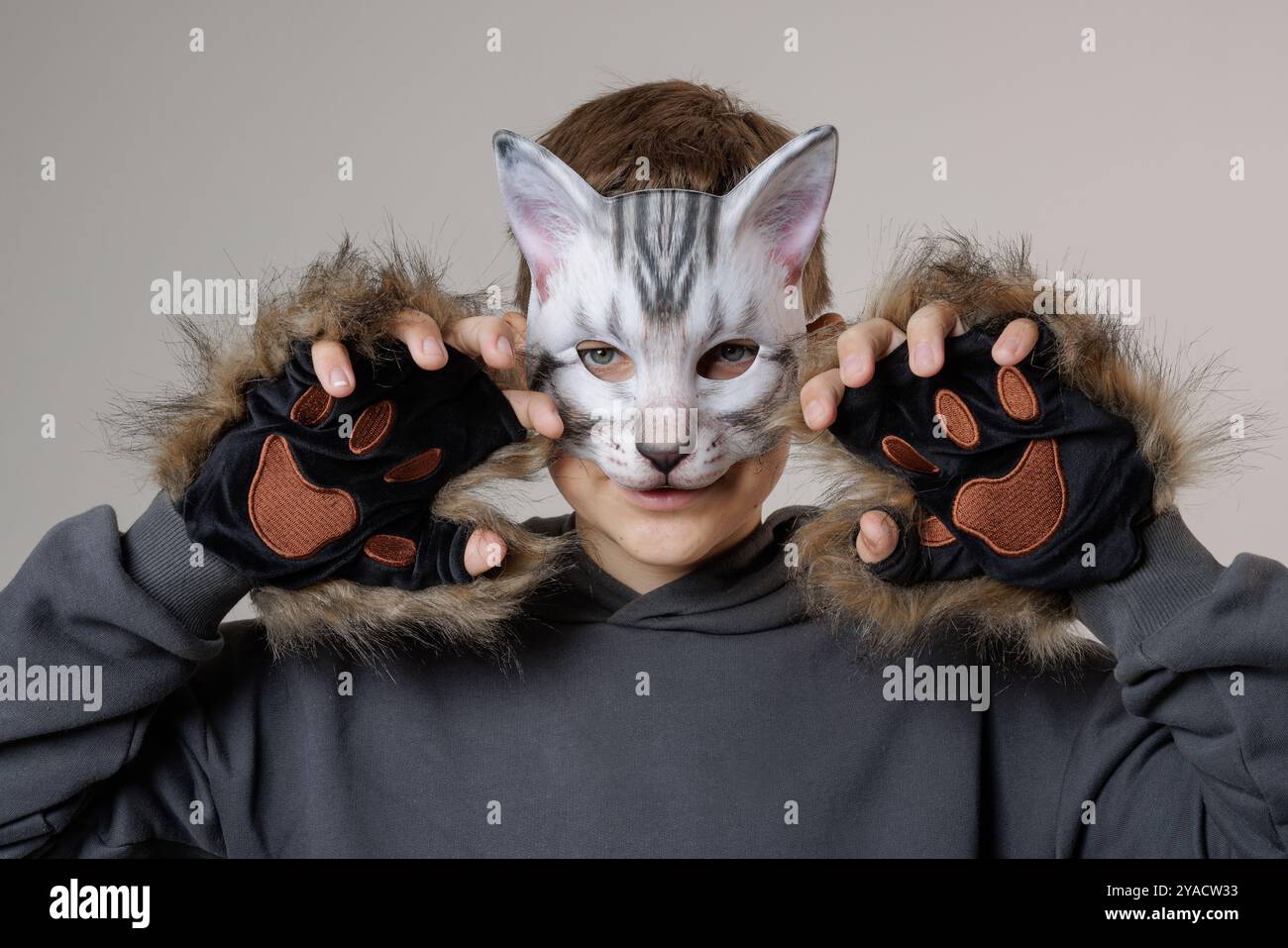 portrait quadrobics Teenager in cat mask on gray background , studio ...