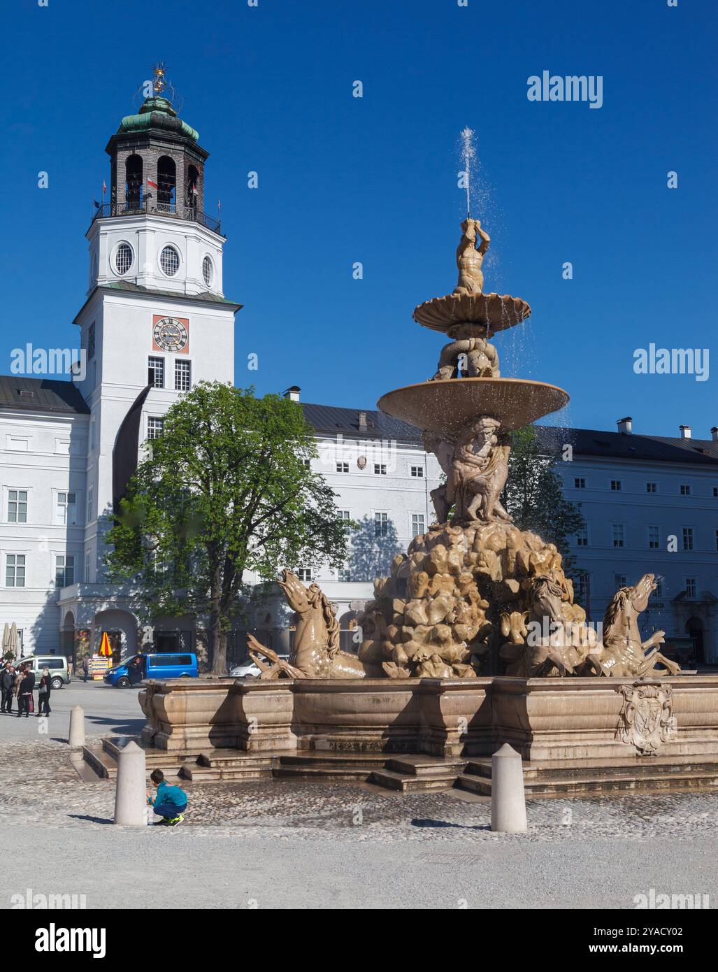 The Fountain and Salzburg Museum with its clock tower at Residentzplatz ...