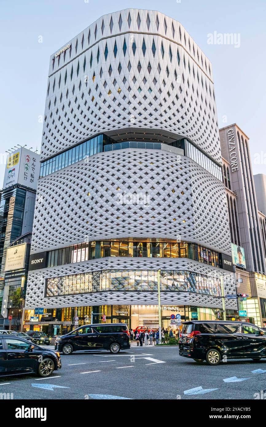 The illuminated white clad landmark Ginza Place building with the Gina Core building on a late ...