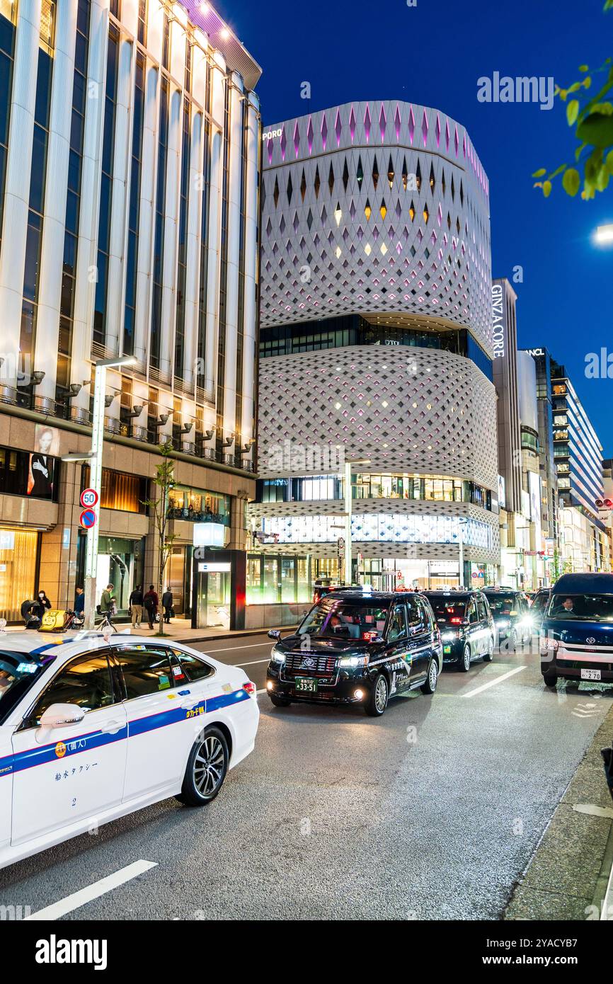 View along a row of taxicabs in the street with behind them the landmark white clad Ginza Place ...
