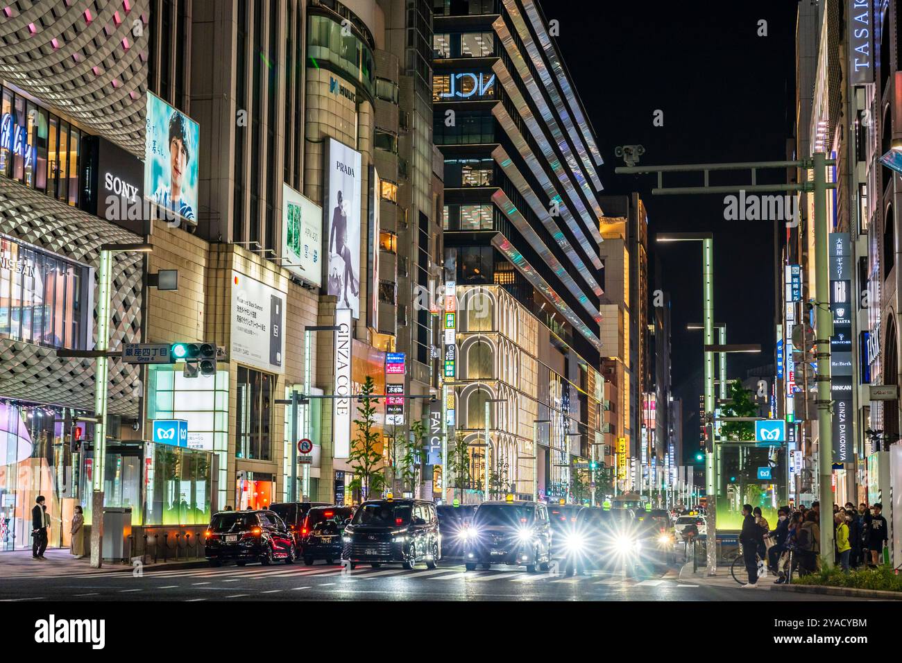 Traffic waiting on the famous Ginza 4 crossroads at night with background of the Ginza Core and ...