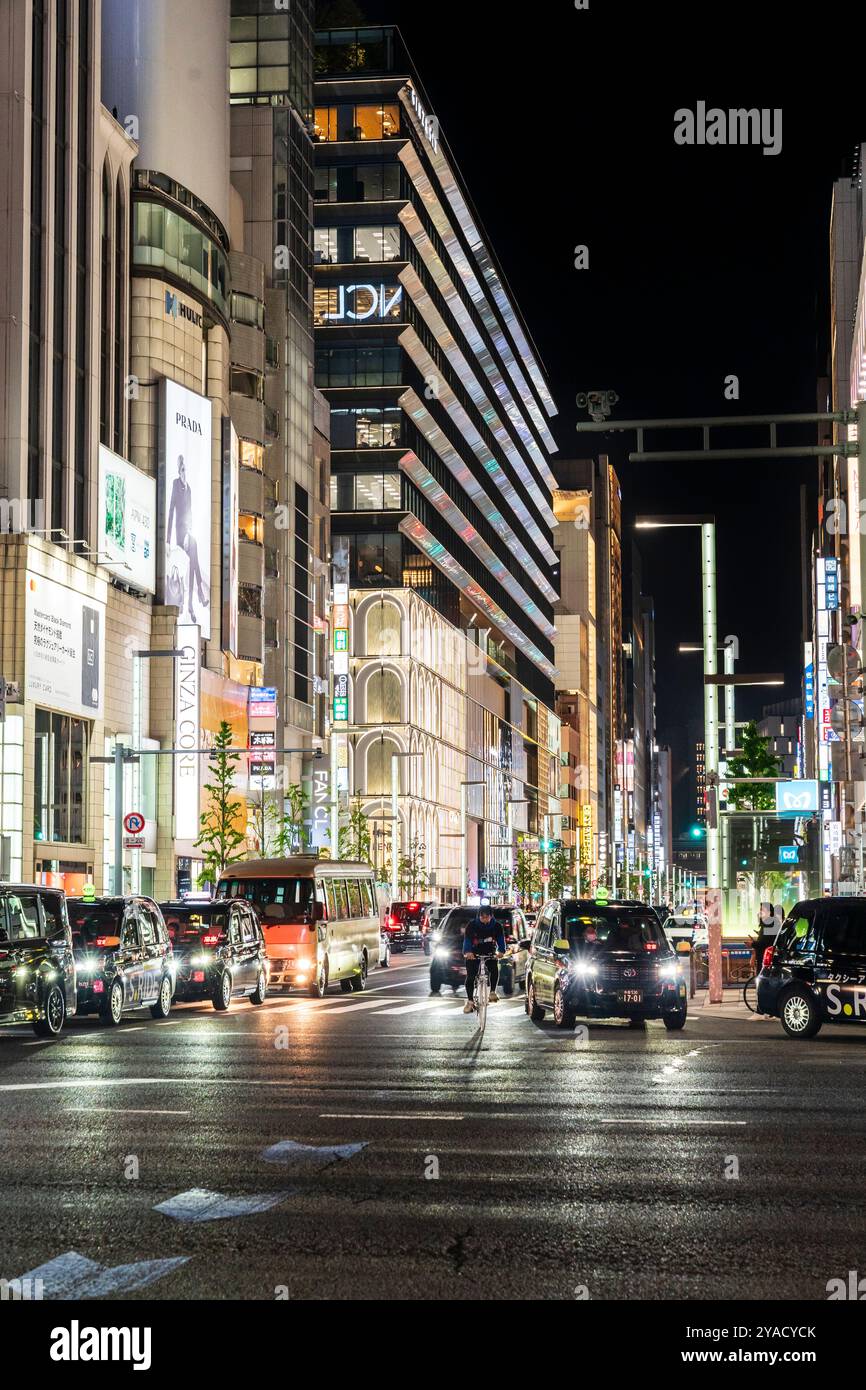 Traffic crossing the famous Ginza 4 crossroads at night with background of the Ginza Core and ...