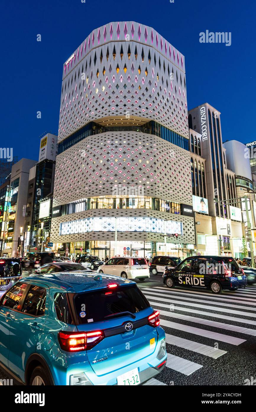 Across road view of the illuminated white clad landmark Ginza Place building with the Gina Core ...