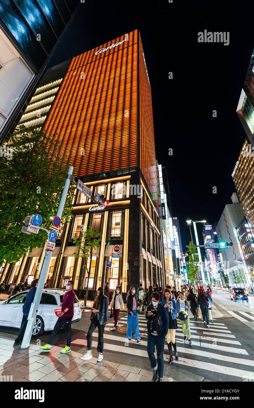 Busy scene with people crossing the road outside the corner towering ...