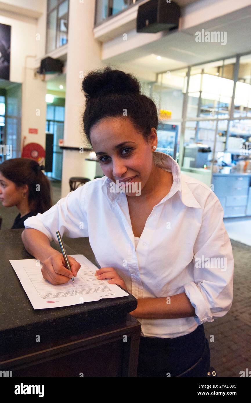 Portrait Woman. Young adult woman working on a Model Release Form while ...