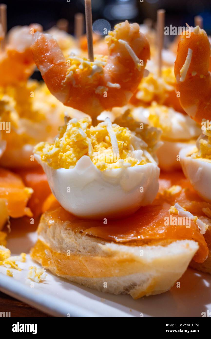 Typical snacks of Basque Country, pinchos or pinxtos skewers with small ...