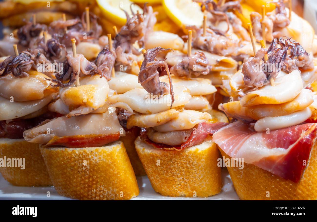 Typical snacks of Basque Country, pinchos or pinxtos skewers with small ...
