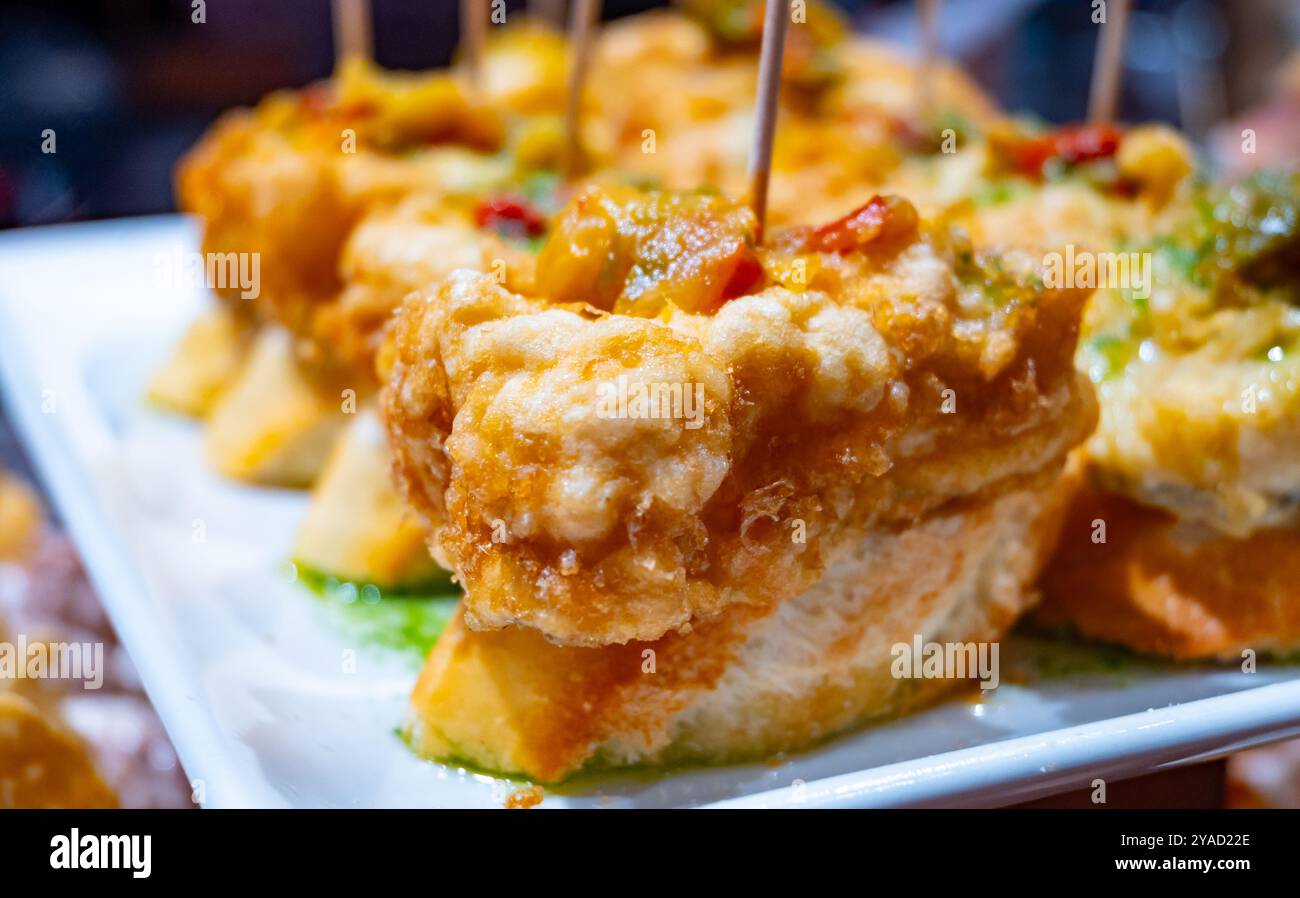 Typical snacks of Basque Country, pinchos or pinxtos skewers with small ...