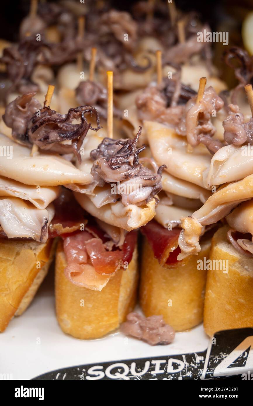 Typical snacks of Basque Country, pinchos or pinxtos skewers with small ...