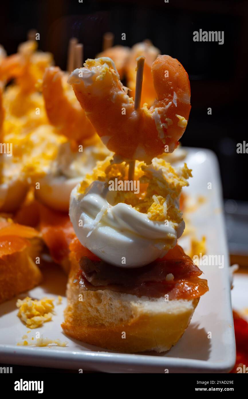 Typical snack of Basque Country, pinchos or pinxtos skewers with small ...