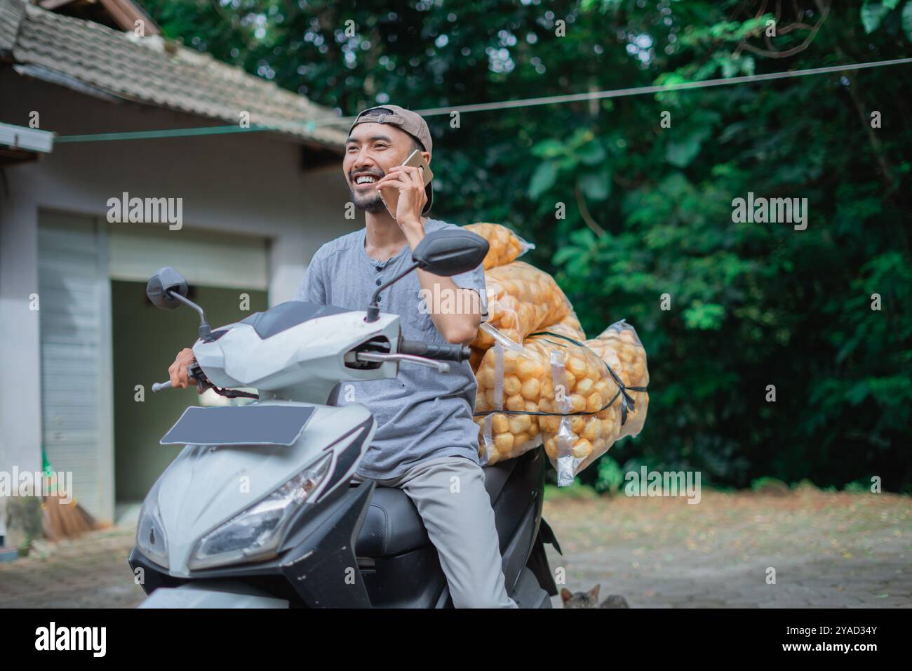 A Smiling Delivery Rider on a Scooter Delivering Fresh Produce and ...
