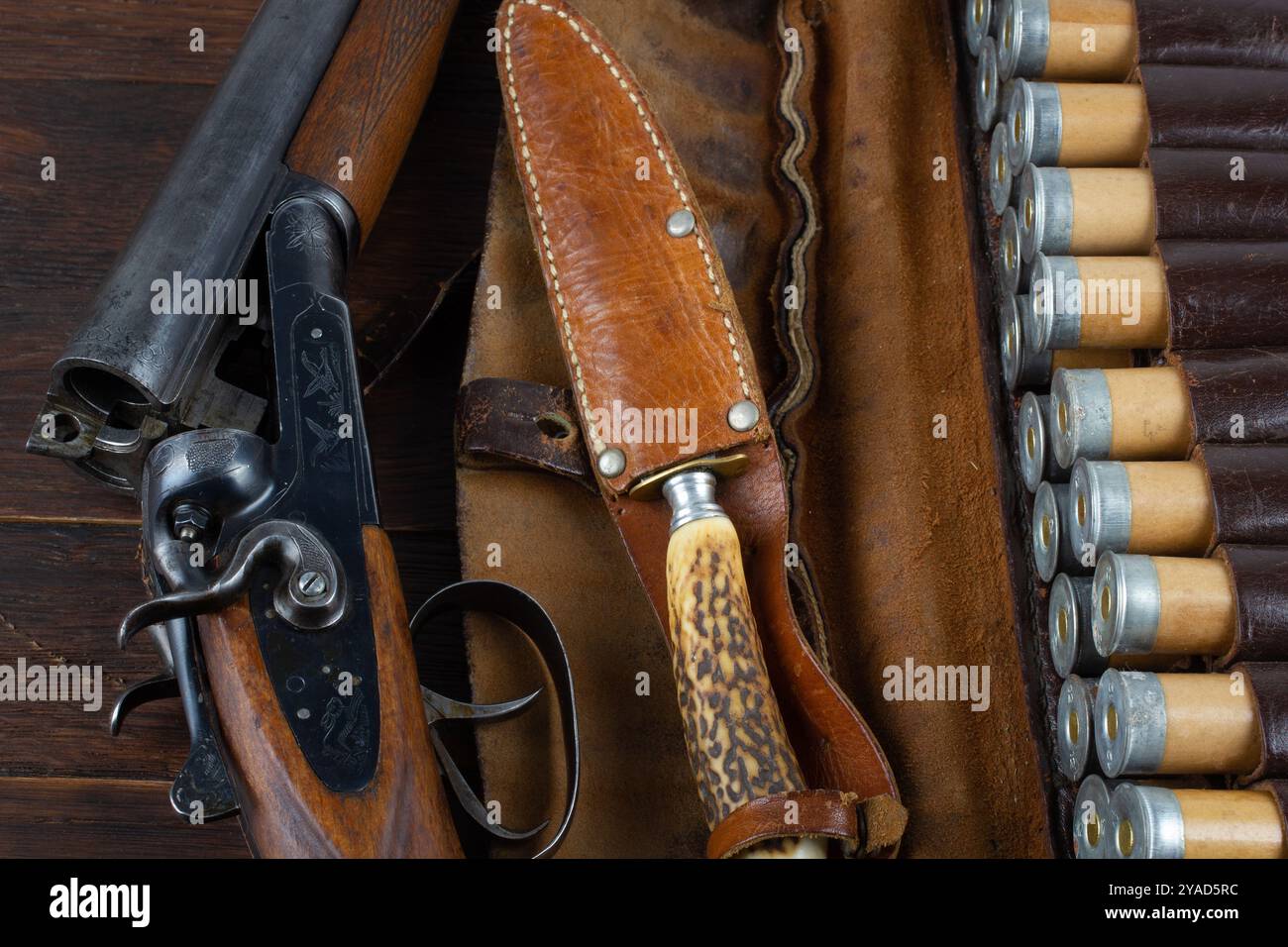 double barreled side shotgun with cartridges in bandolier on wooden ...