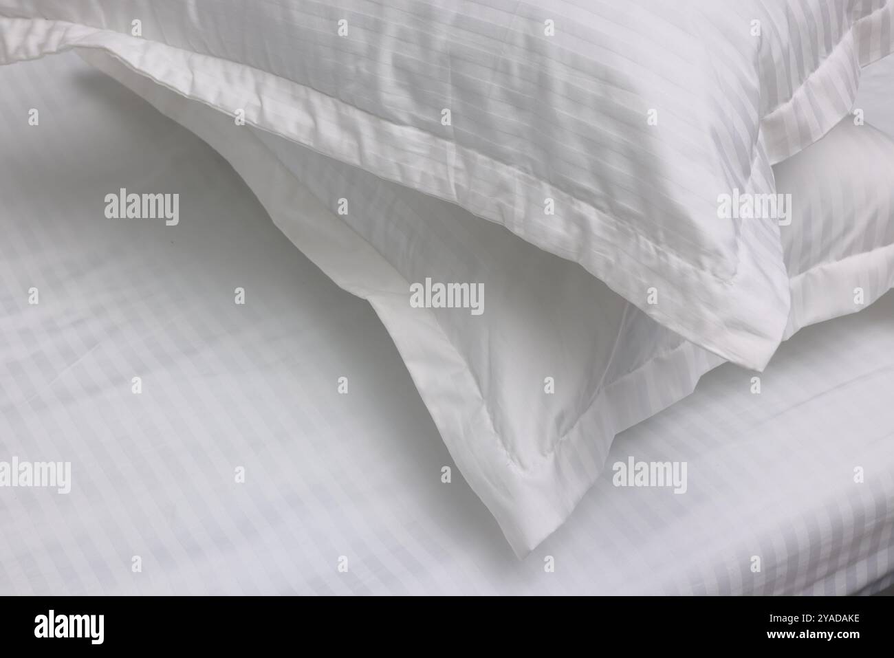 Bed with white clean linens and pillows Stock Photo - Alamy