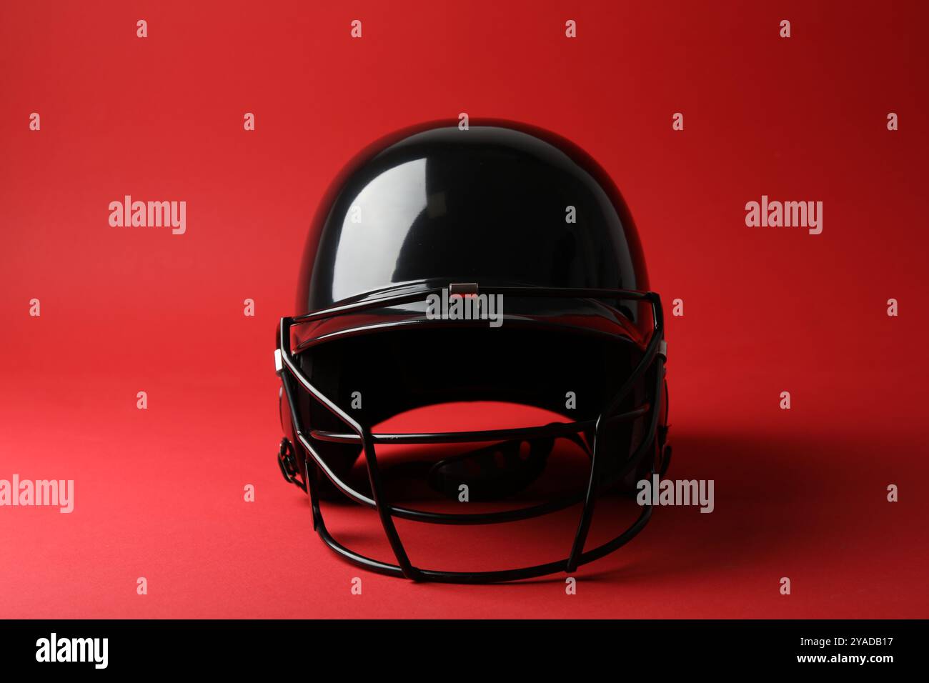 One black baseball helmet on red background Stock Photo - Alamy