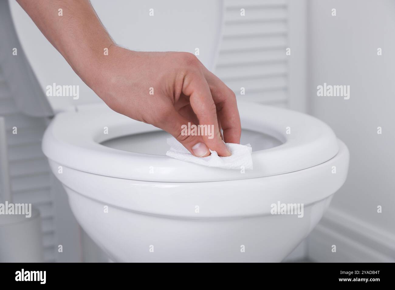 Man wiping toilet seat with paper in bathroom, closeup Stock Photo - Alamy