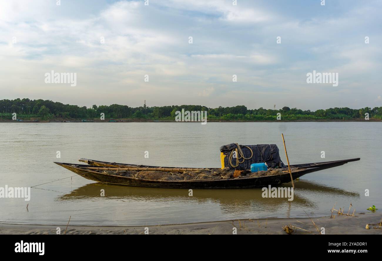 Riverside of Bangladesh. A hilsa fishing boat on the river bank. River ...