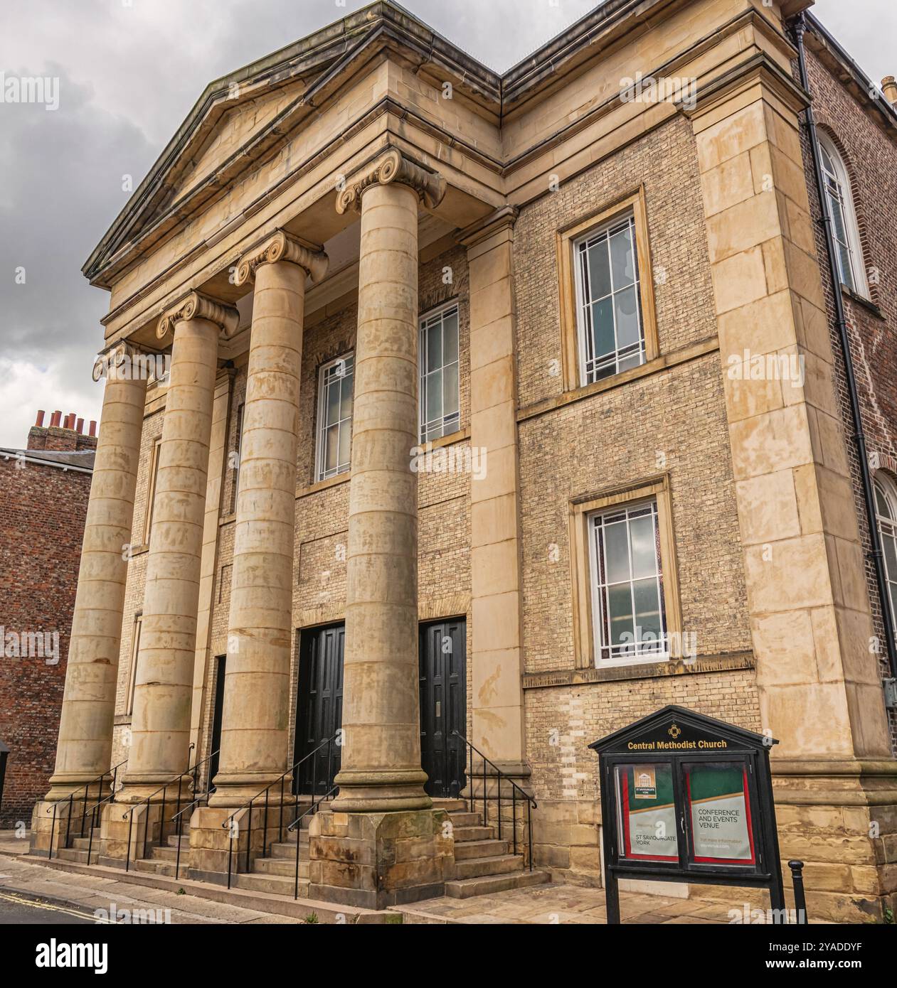 Tall columns at the entrance to a Methodist Church. Steps with ...