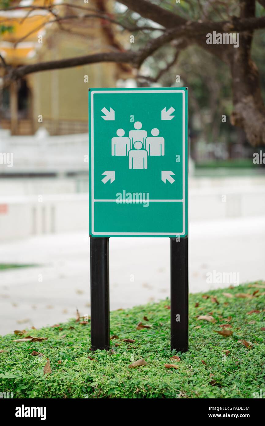 An assembly point sign, prominently displayed against a backdrop of a ...