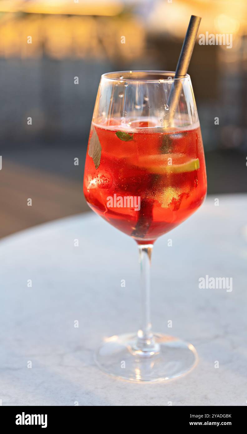 tarnished wine glass filled with Lillet wild berry and metal straw ...