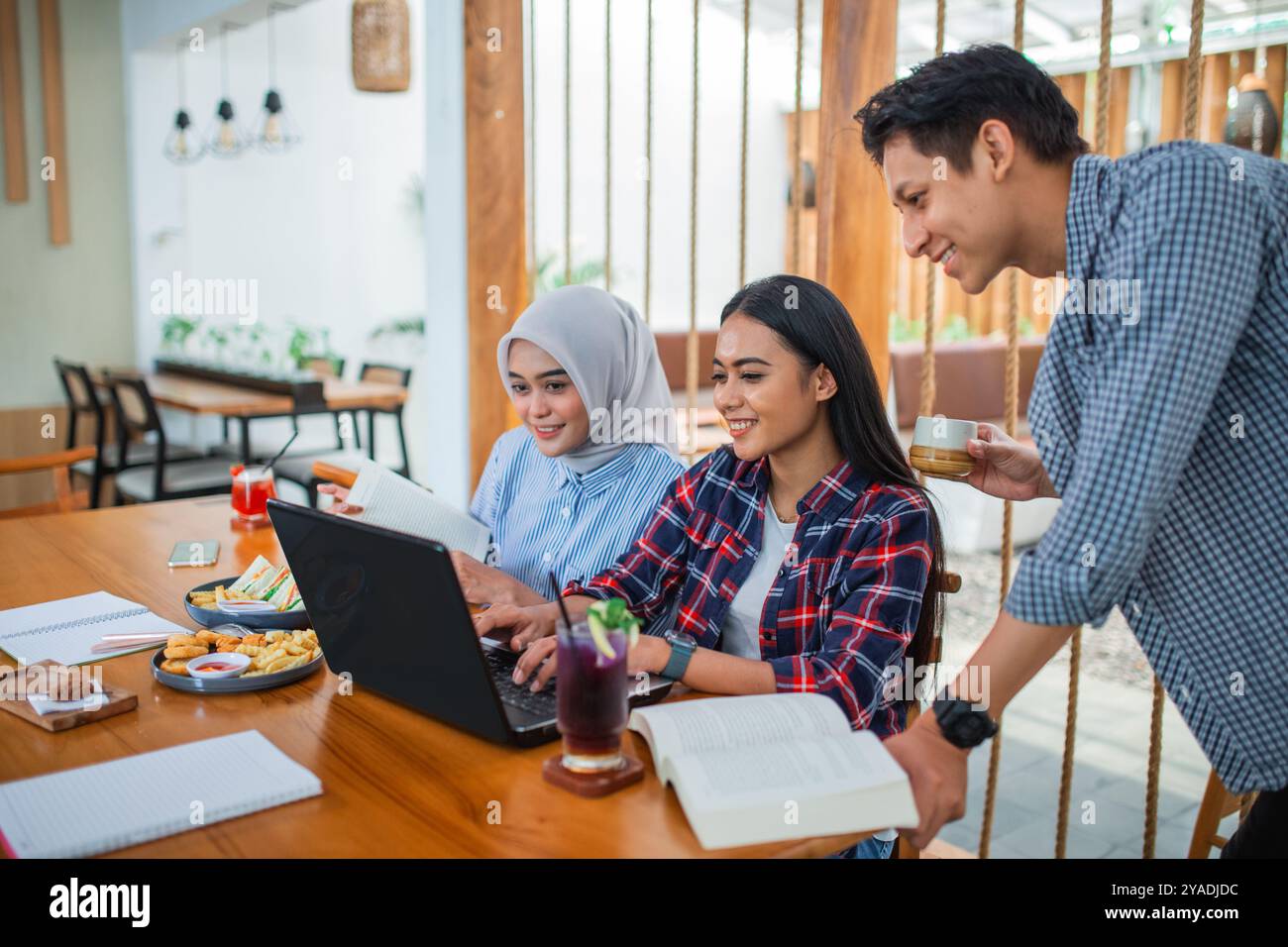 Group of indonesian students studying together using laptop in the ...