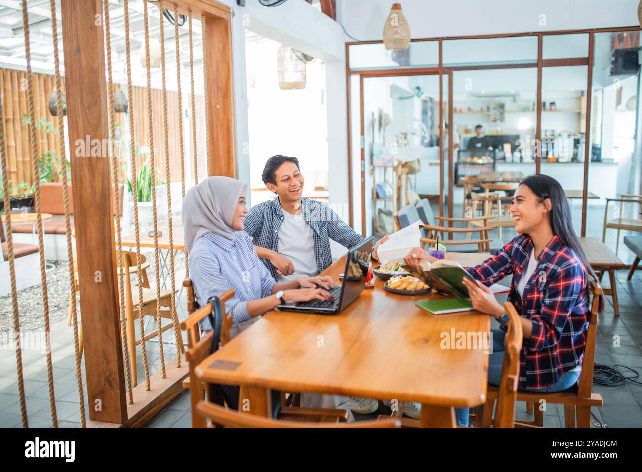 three students learning and group work in a coffee shop Stock Photo - Alamy