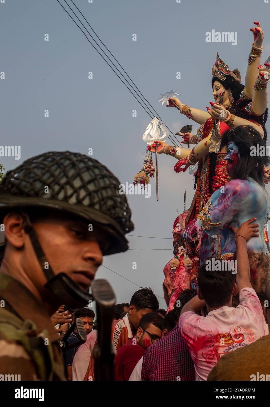 Hindu devotees carry an idol of the goddess Durga during the final day ...